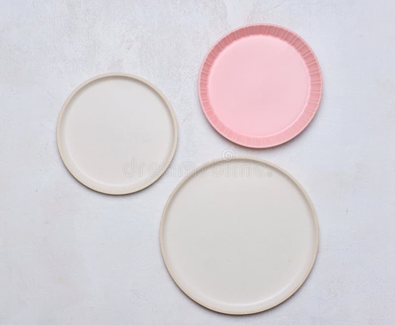 Two Beige Empty Ceramic Plates of Different Shapes and a Pink Baking ...