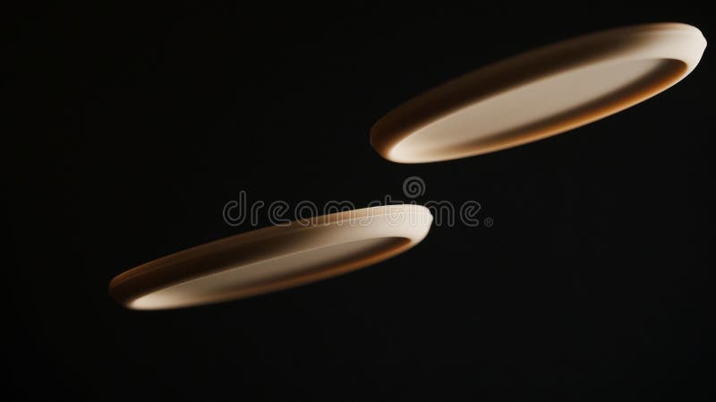 Two Beige Plates Floating in Mid-air Against a Stark Black Backdrop ...