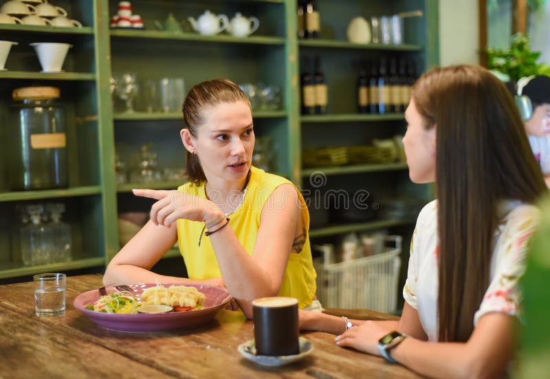 Two Best Friends Talking and Eating in a Cafe Stock Image - Image of ...
