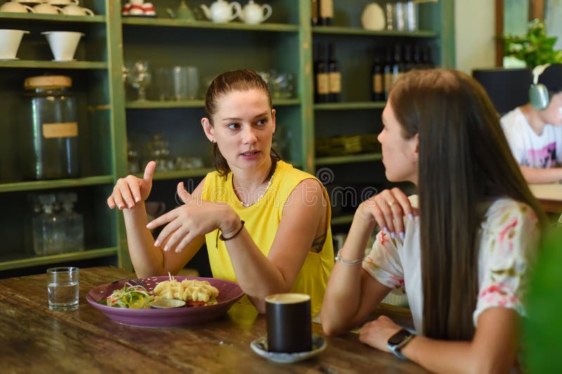 Two Best Friends Talking and Eating in a Cafe Stock Photo - Image of ...