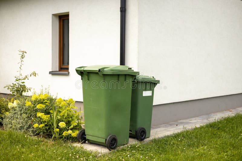 Two Big Empty Green Plastic Trash Garbage Bin in Front of the Modern ...