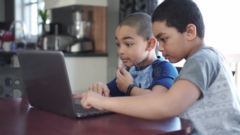 Two Black Boy Sitting Playing on a Laptop Computer at Home Stock Video ...