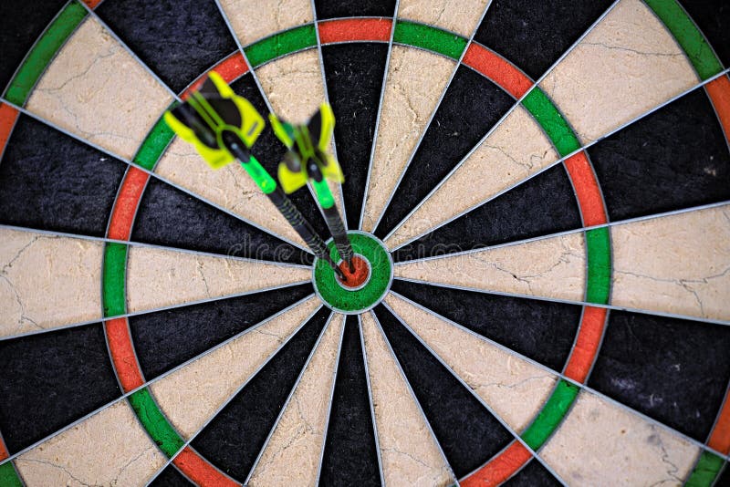 Two Black and Green Darts Stuck in the Bullseye of a Dartboard. Close ... Two Black and Green Darts Stuck in the Bullseye of a Dartboard. Close ...