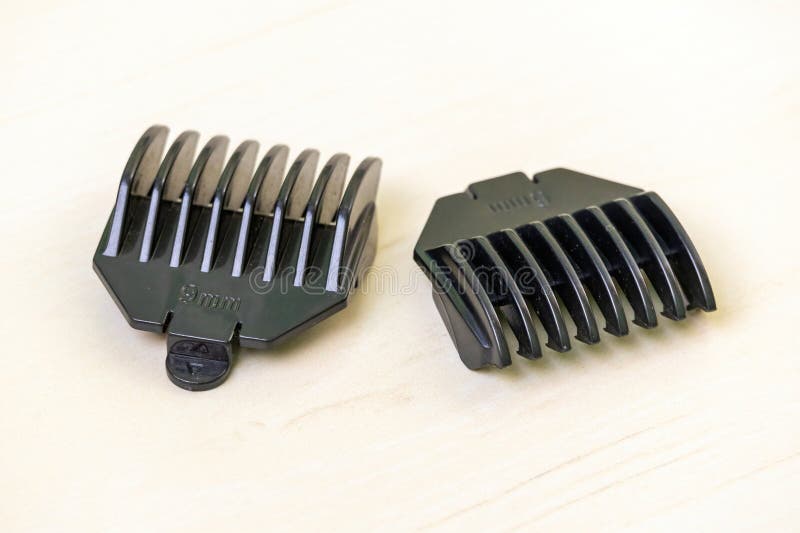 Two Black Hair Clipper Guards of Varying Lengths are Arranged on a ...
