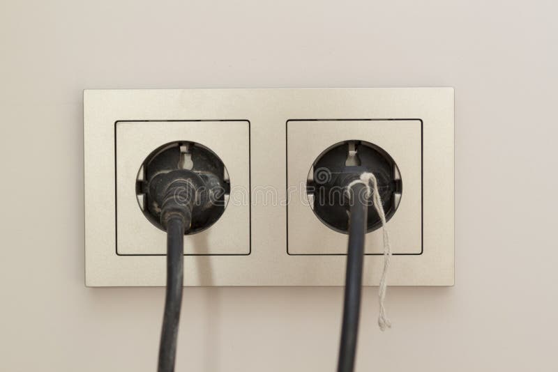 Two Black Plugs are Plugged into a Double Electrical Outlet with a ...