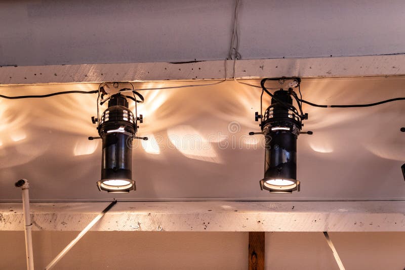 Two Black Studio Spotlights Under a Ceiling Against White Wall. Stock ...