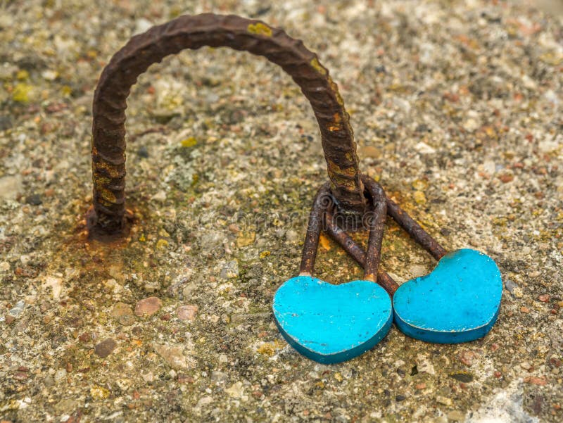 Two Blue Heart Padlocks Fastened To a Rusty Metal Loop on Concrete ...
