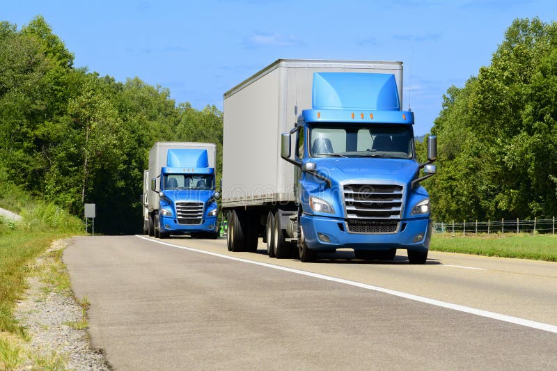 Two Blue Semis Travel Down an Interstate Highway Stock Photo - Image of ...