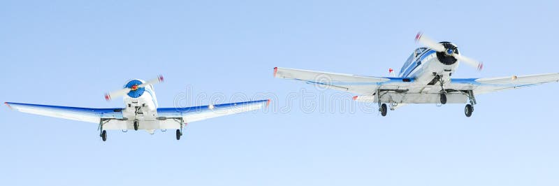 Two Blue-and-white Aircraft with Propellers Flying Next To Each Other ...