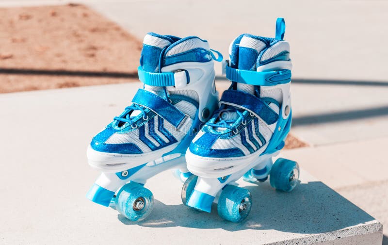 Two Blue and White Roller Skates Standing Side by Side on a Concrete ...