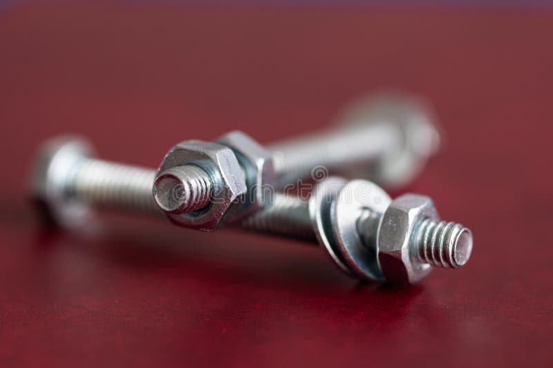 Two Bolts Laying One Over Another on Dark Red Background Stock Image ...