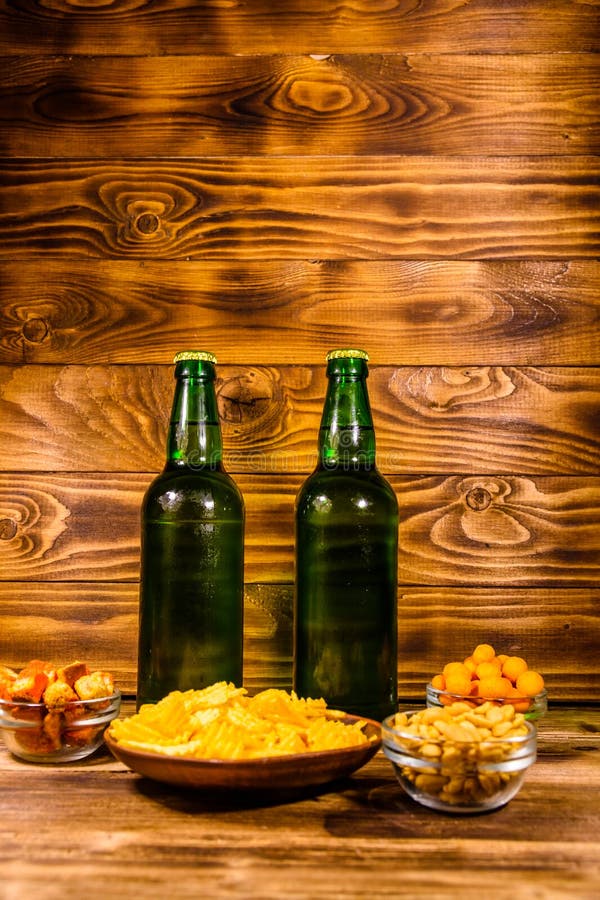 Two Bottles of Beer and Different Snacks on Wooden Table Stock Image ...