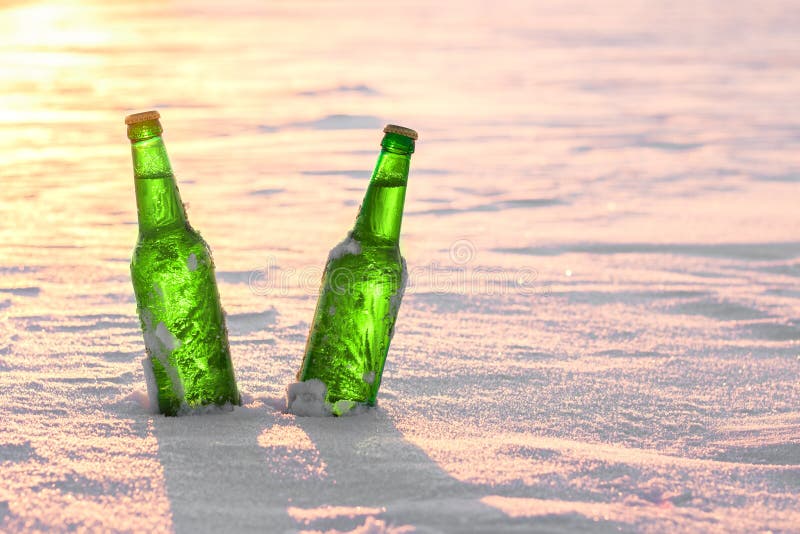 Two Bottles of Cold Beer on the Snow at Sunset. Stock Image - Image of ...