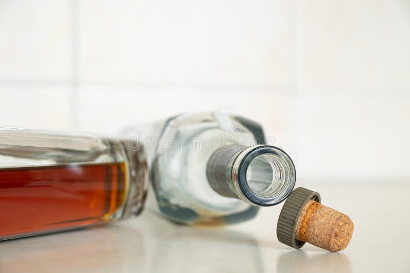 Two Bottles, One Full One Empty with Cognac and a Cork on the Table in ...