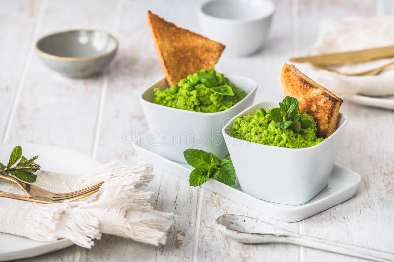 Two Bowls of Pea Puree with Basil, Mint and Roasted Bread on Rustic ...