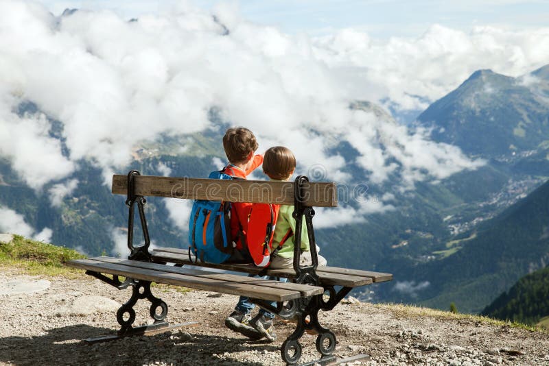 Two Boy Sit on Bench in Alps Stock Photo - Image of green, hill: 69918680