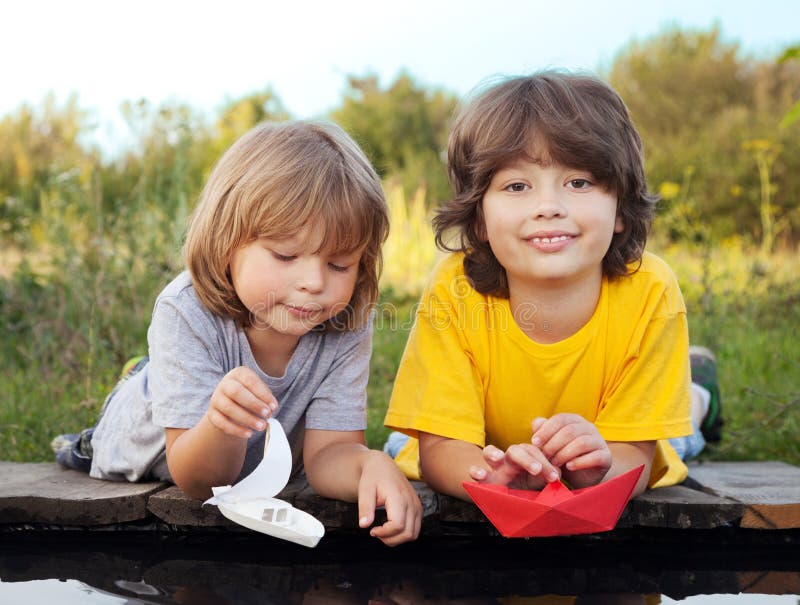 Two Boys Allowed Paper Boats from the Pier of River Stock Image - Image ...