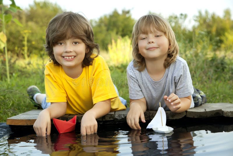 Two Boys Allowed Paper Boats from the Pier of the River Stock Photo ...