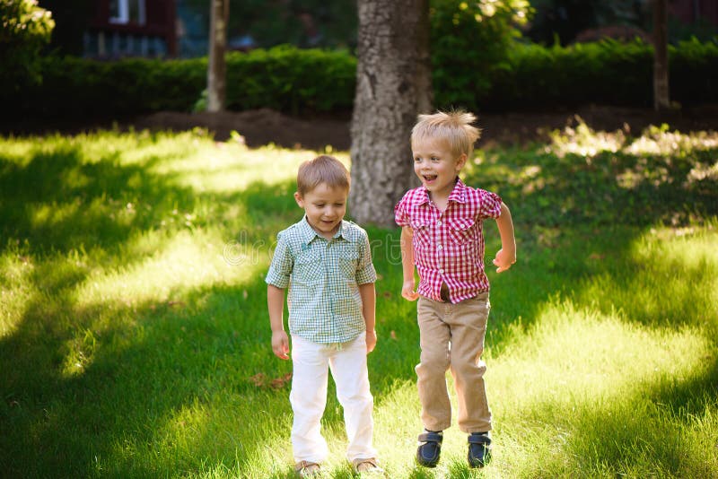 Two Boys Brothers Playing and Jumping Outdoors in a Park. Stock Photo ...