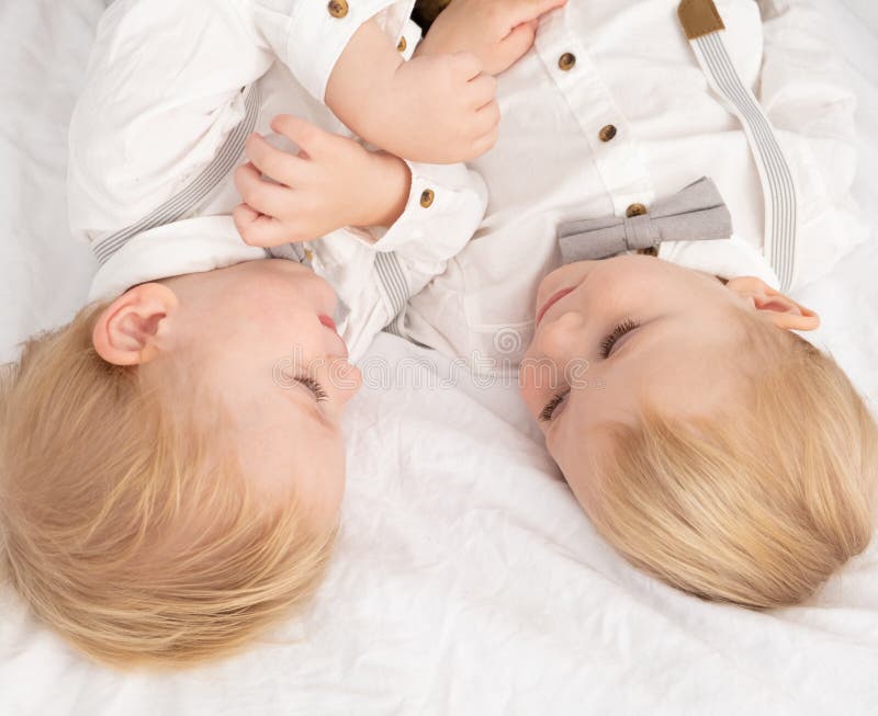 Two Boys Brothers Twins In White Shirts Looking At Each Other. Stock ...