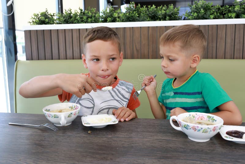 Two boys eating Dumplings stock photo. Image of human - 161705852