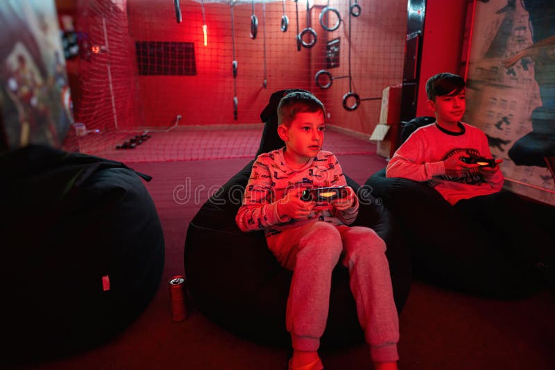 Two Boys Gamers Play Gamepad Video Game Console in Red Gaming Room ...
