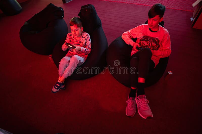 Two Boys Gamers Play Gamepad Video Game Console in Red Gaming Room ...
