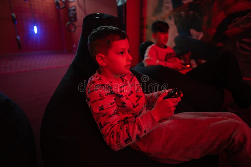Two Boys Gamers Play Gamepad Video Game Console in Red Gaming Room ...
