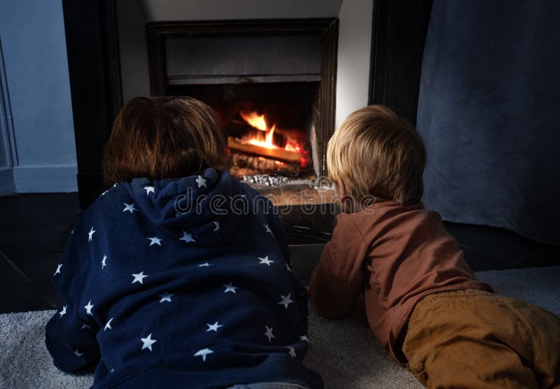 Two Boys Lay in Front of the Home Fireplace Look at Fire Stock Image ...