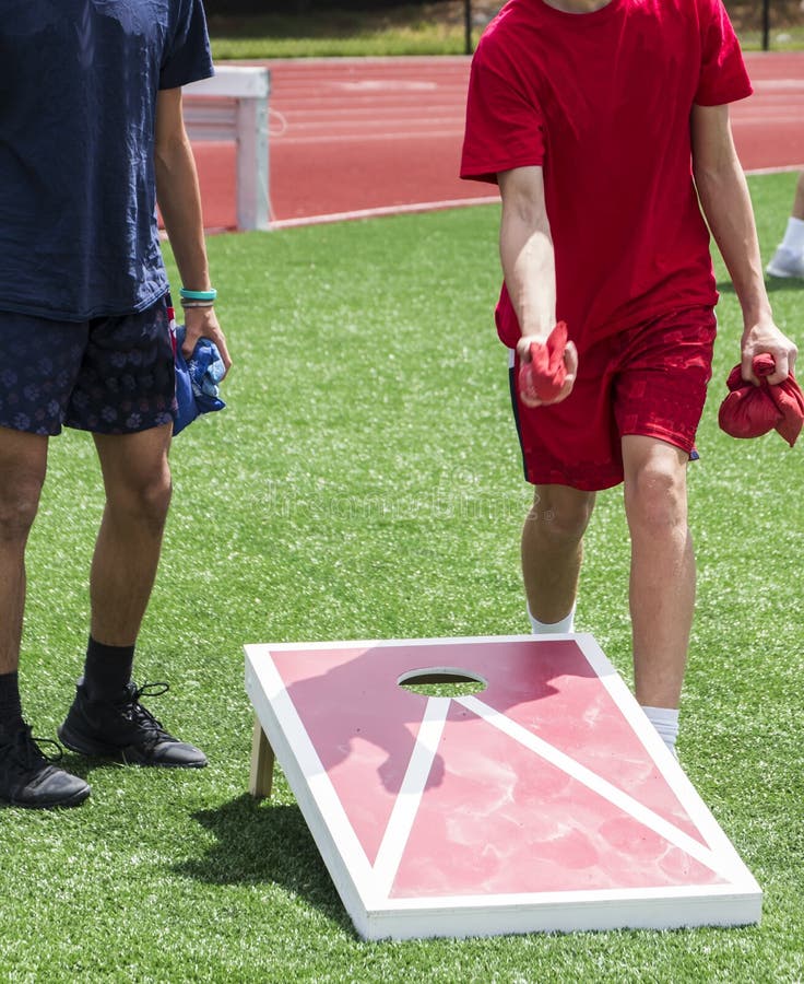 Two boys playing corn hole stock photo. Image of white - 123009514