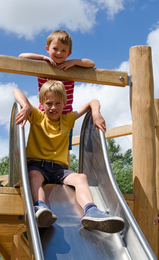 Two Boys Playing on a Slide Stock Image - Image of playing, male: 33743435
