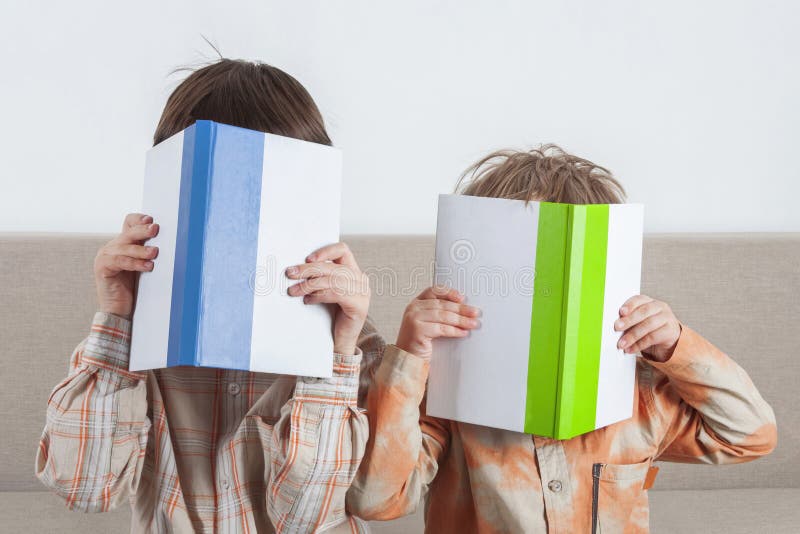 Two Boys Read Books. they Cover Their Faces with a Book Stock Image ...
