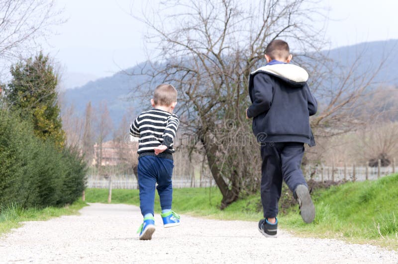Two boys run on rural road stock image. Image of village - 68214981