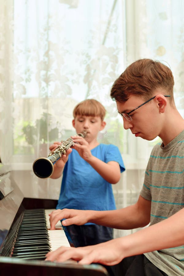 Two Boys Study at a Music School and Play the Clarinet and Piano Stock ...
