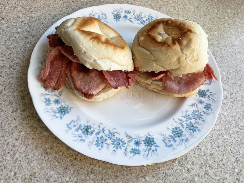 Two Bread Rolls or Baps on a Plate with Bacon in. Stock Photo - Image ...