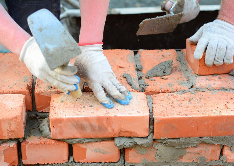 Two Bricklayers are Laying Bricks of a Brick Wall, Foundation Using a ...