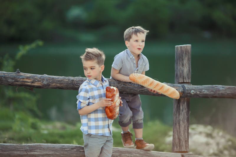 Two Brothers Eat Black Round Bread on a Wheat Field. Stock Image ...