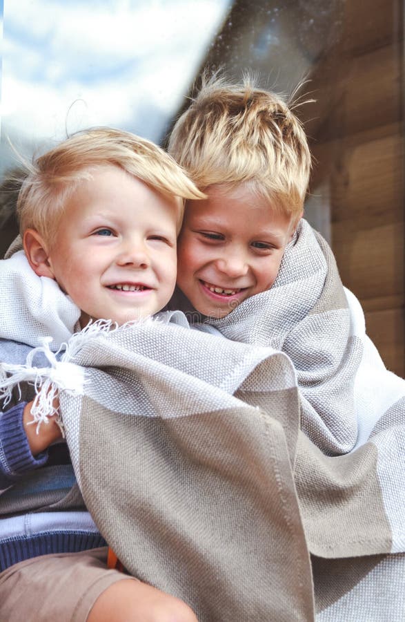 Two Brothers Hug and Have Fun Together Under a Warm Plaid Stock Photo ...