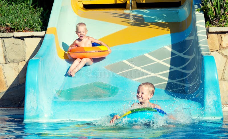 Two Brothers in an Inflatable Rubber Circles Move Down the Water Slide ...
