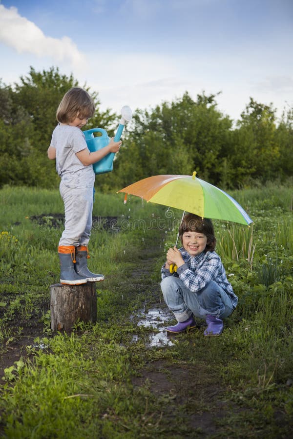 Two Brothers Play in Rain Outdoors Stock Photo - Image of female, play ...