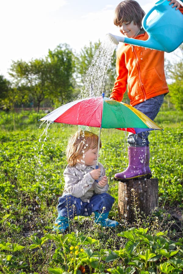 Two brothers play in rain stock image. Image of activity - 40989577