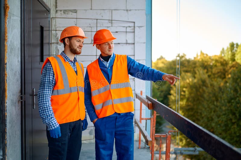 Two Builder Standing Talking at Construction Site Stock Photo - Image ...