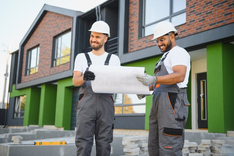 Two Builders or Architects Checking the Construction Plan Against the ...