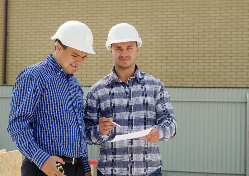 Two Builders or Engineers Discussing Paperwork Stock Photo - Image of ...