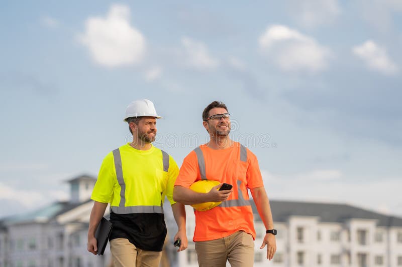 Two Builders in a Hard Hat is Busy Working on a Construction Project at ...