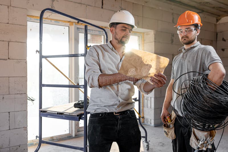 Two Builders Look at the Drawing of the Object Stock Photo - Image of ...