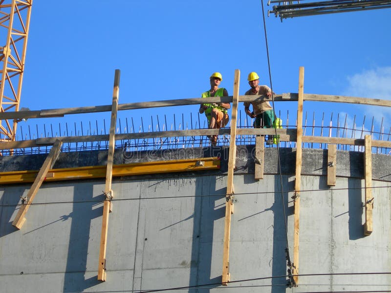 Two Builders. Workers on Top of a Constructed Building Stock Photo ...