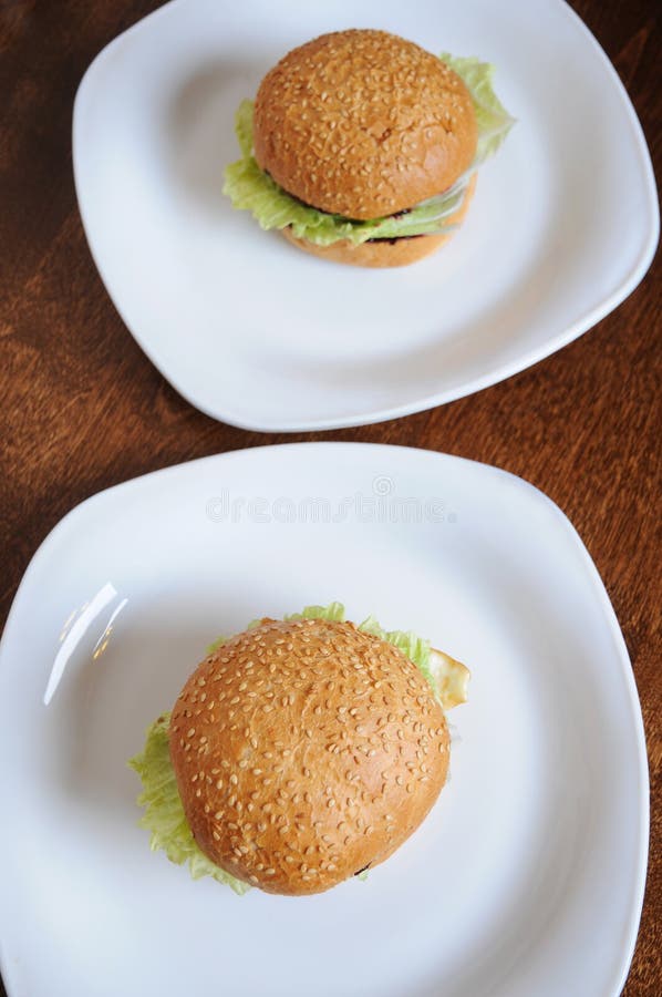 Two Burgers with Greens on a White Plates Top View Stock Image - Image ...
