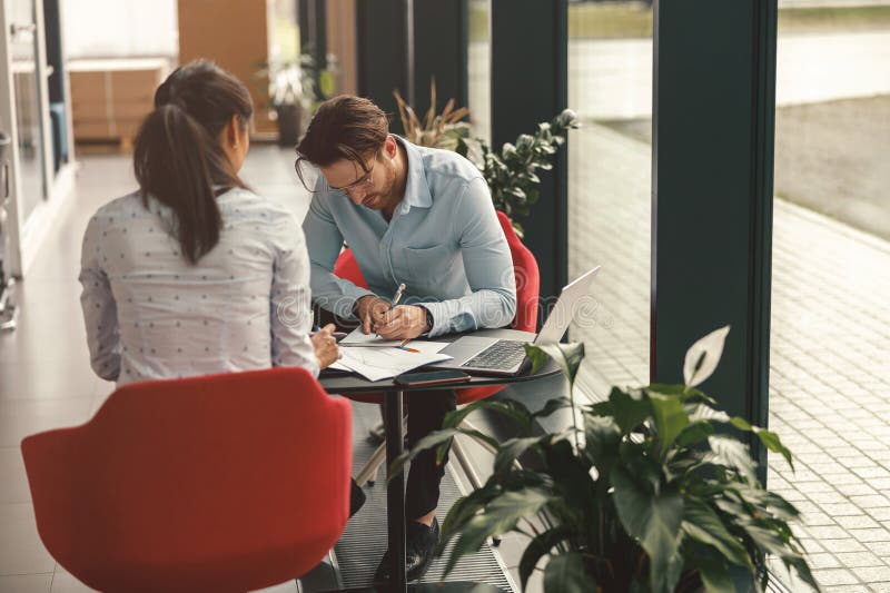 Two Business Colleagues Analysts Working with Documents Together ...