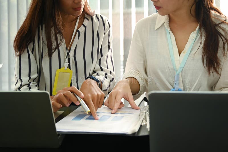 Two Business Colleagues Checking Charts and Discussing Business Trends ...